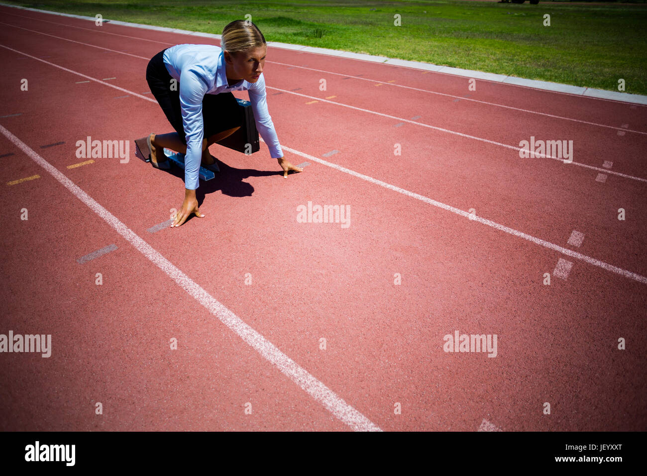 Businesswoman ready to run on running track Stock Photo - Alamy