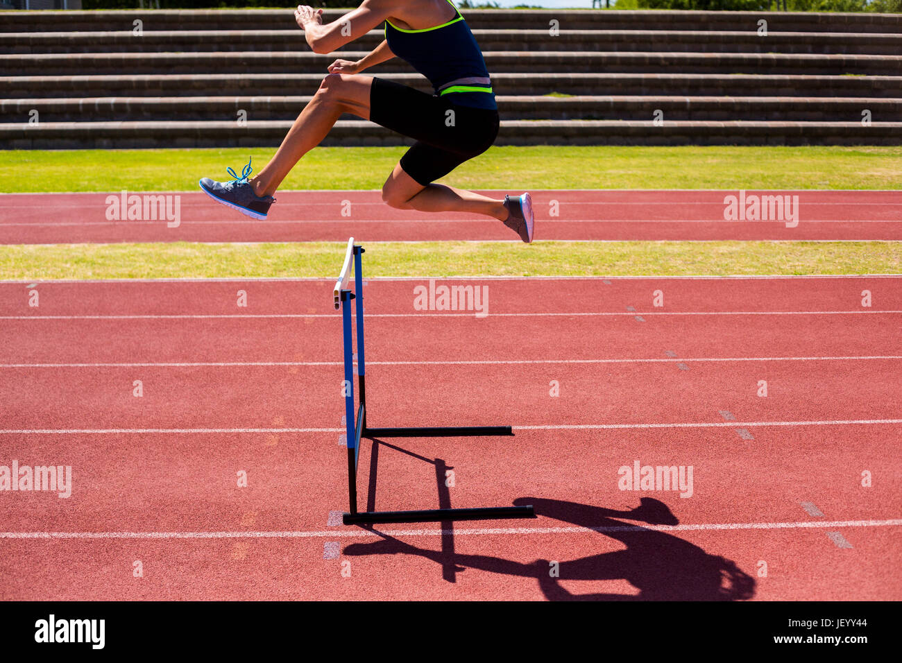 Female athlete jumping above the hurdle Stock Photo - Alamy