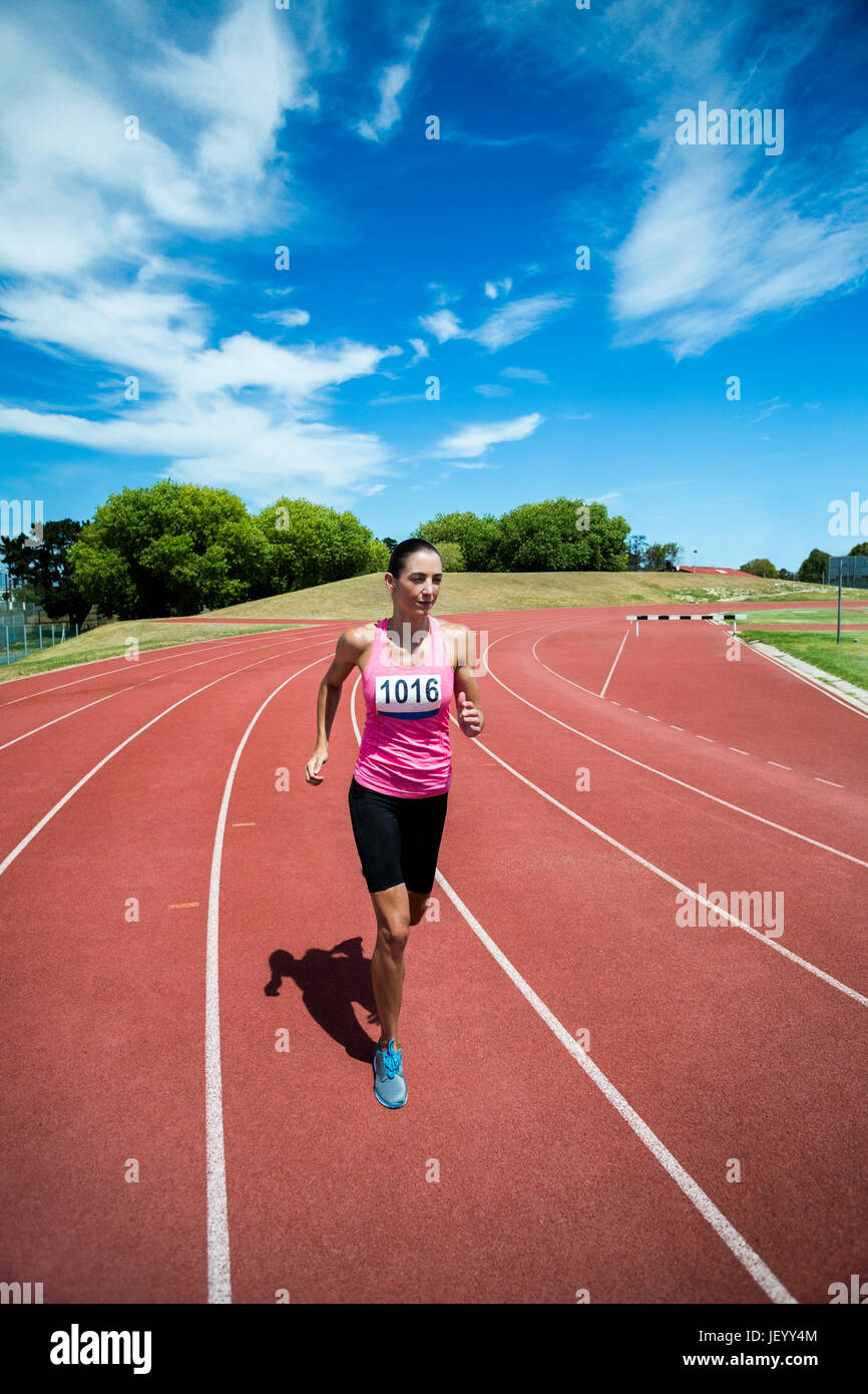Female athlete running on the running track Stock Photo - Alamy