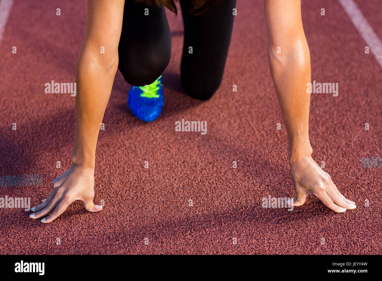 Female athlete in ready to run position Stock Photo - Alamy