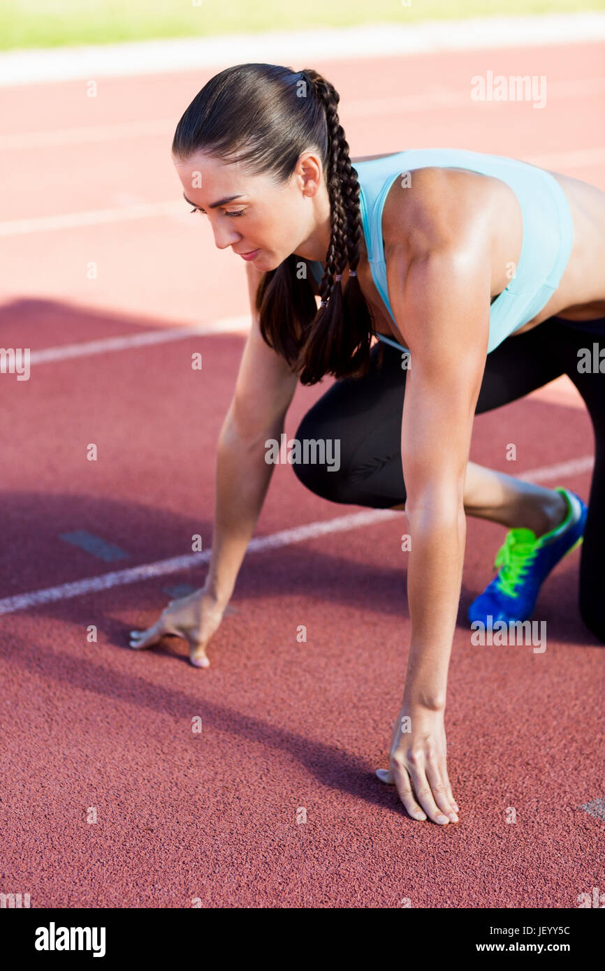 Female athlete in ready to run position Stock Photo - Alamy
