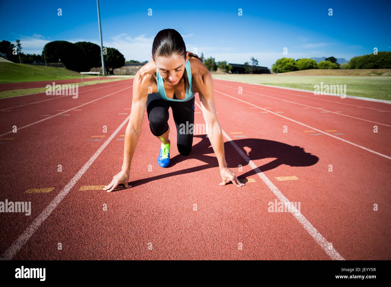 Female athlete in ready to run position Stock Photo - Alamy