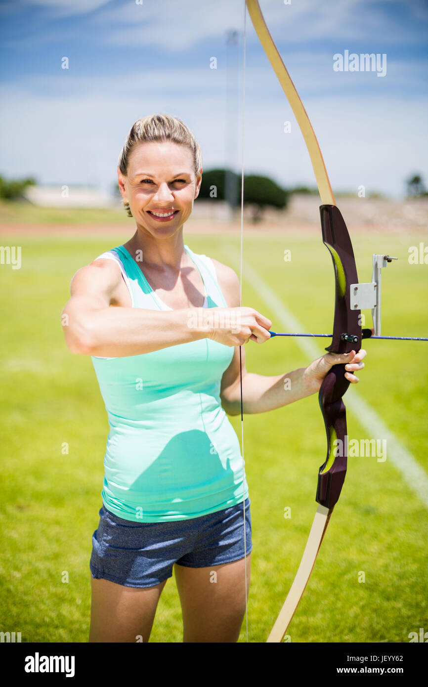 Portrait of female athlete practicing archery Stock Photo - Alamy