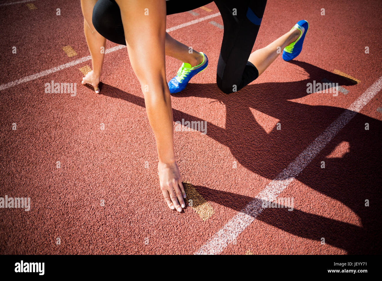 Female athlete in ready to run position Stock Photo - Alamy