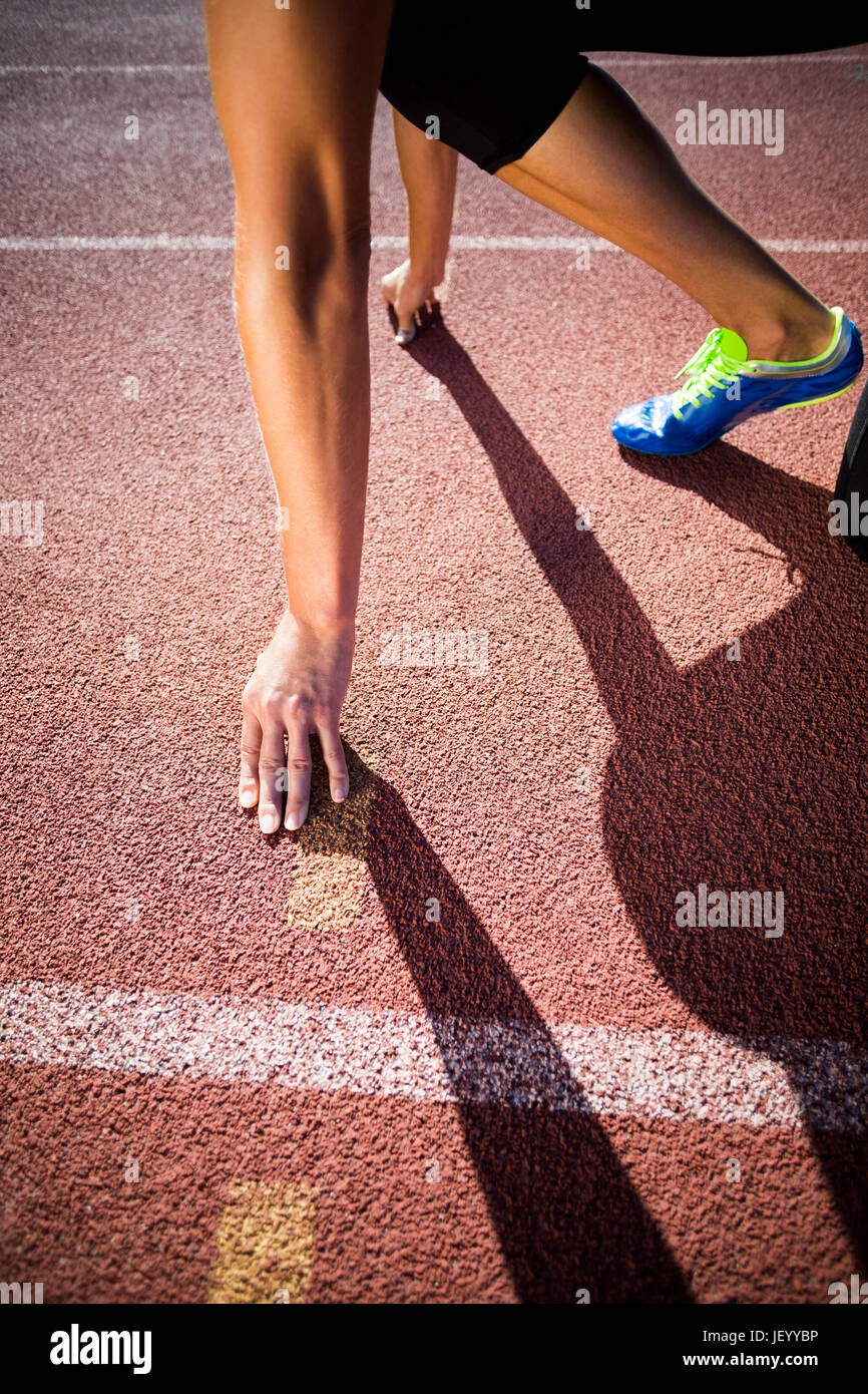 Female athlete in ready to run position Stock Photo - Alamy