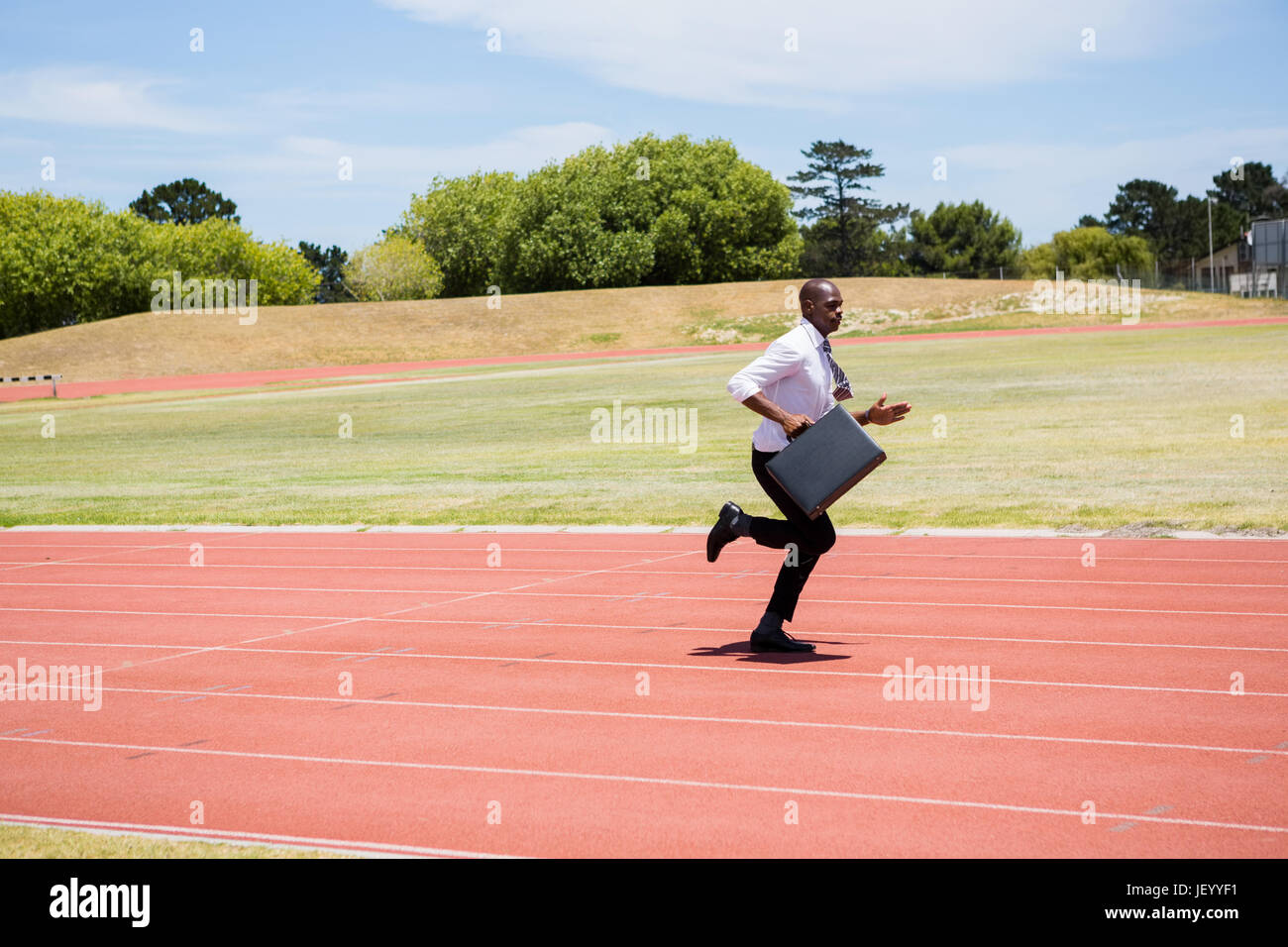 Businessman running on a running track Stock Photo - Alamy