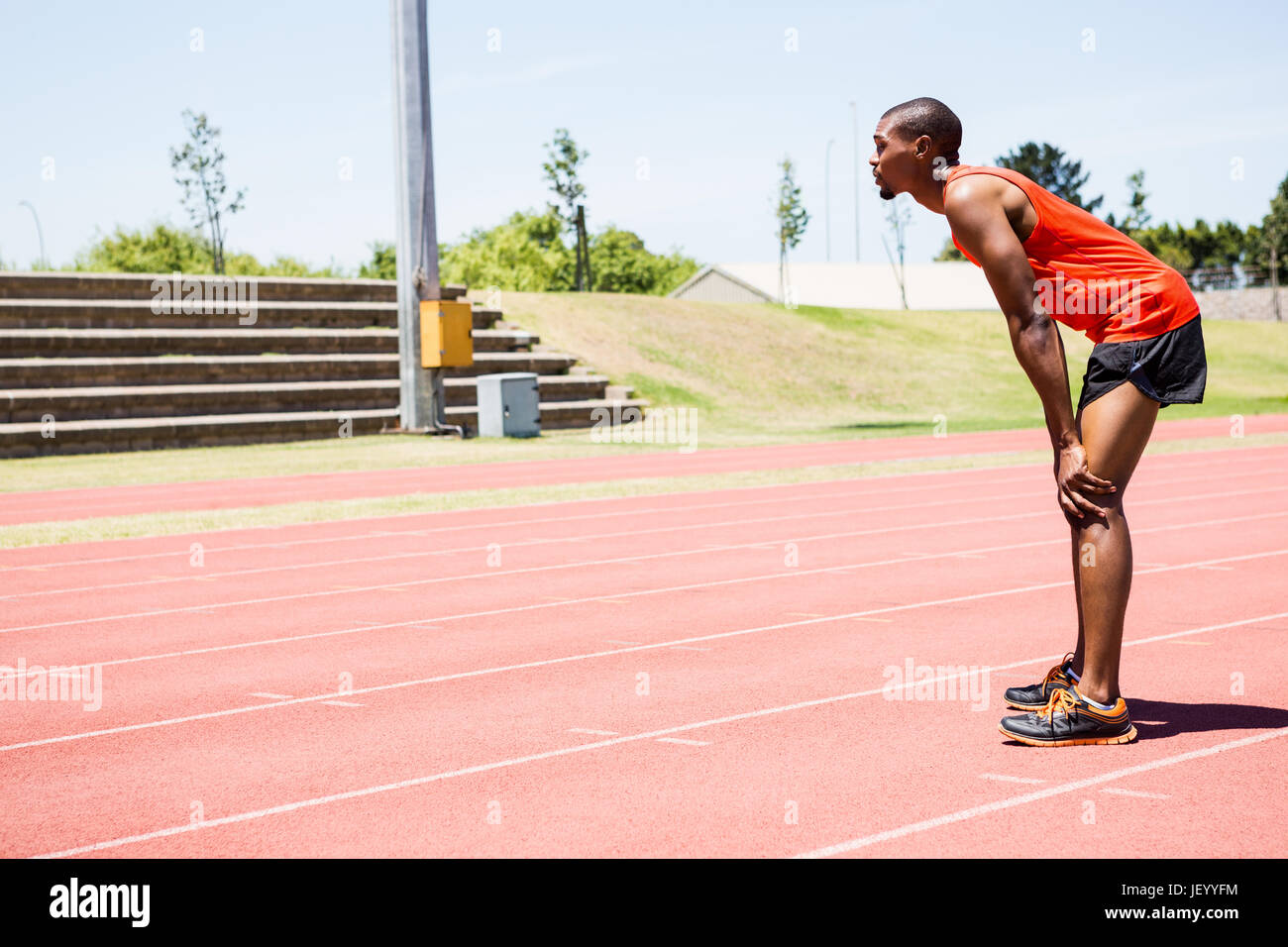 Tired athlete standing on running track Stock Photo - Alamy