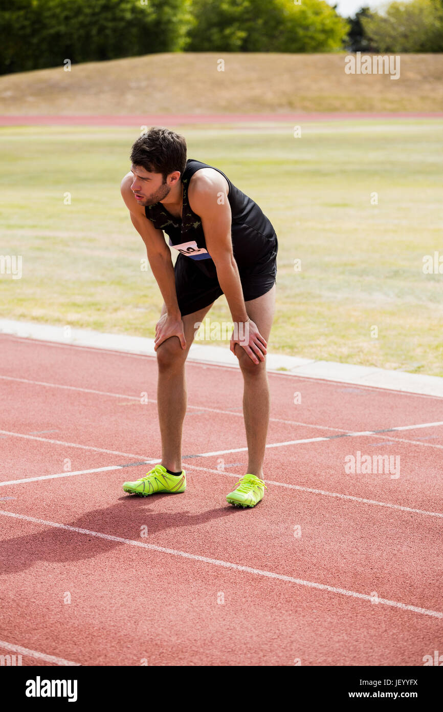 Tired athlete standing on running track Stock Photo - Alamy