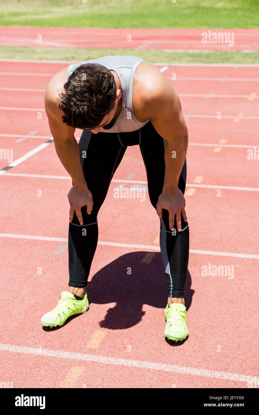 Tired athlete standing on running track Stock Photo - Alamy
