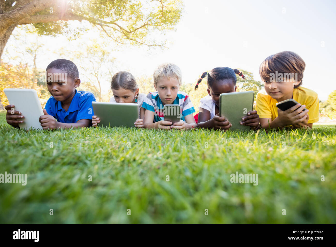 Kids using technology during a sunny day Stock Photo - Alamy
