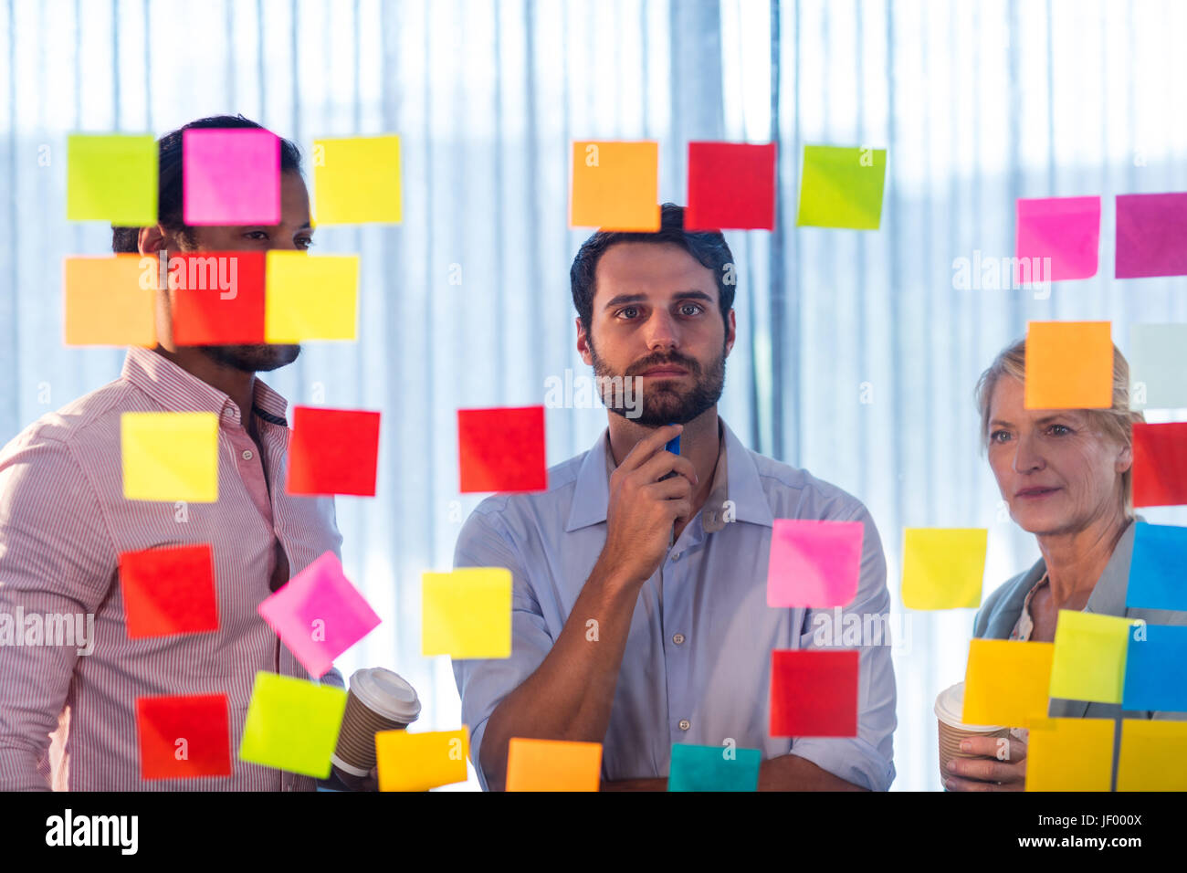 Businessmen reading post it Stock Photo - Alamy