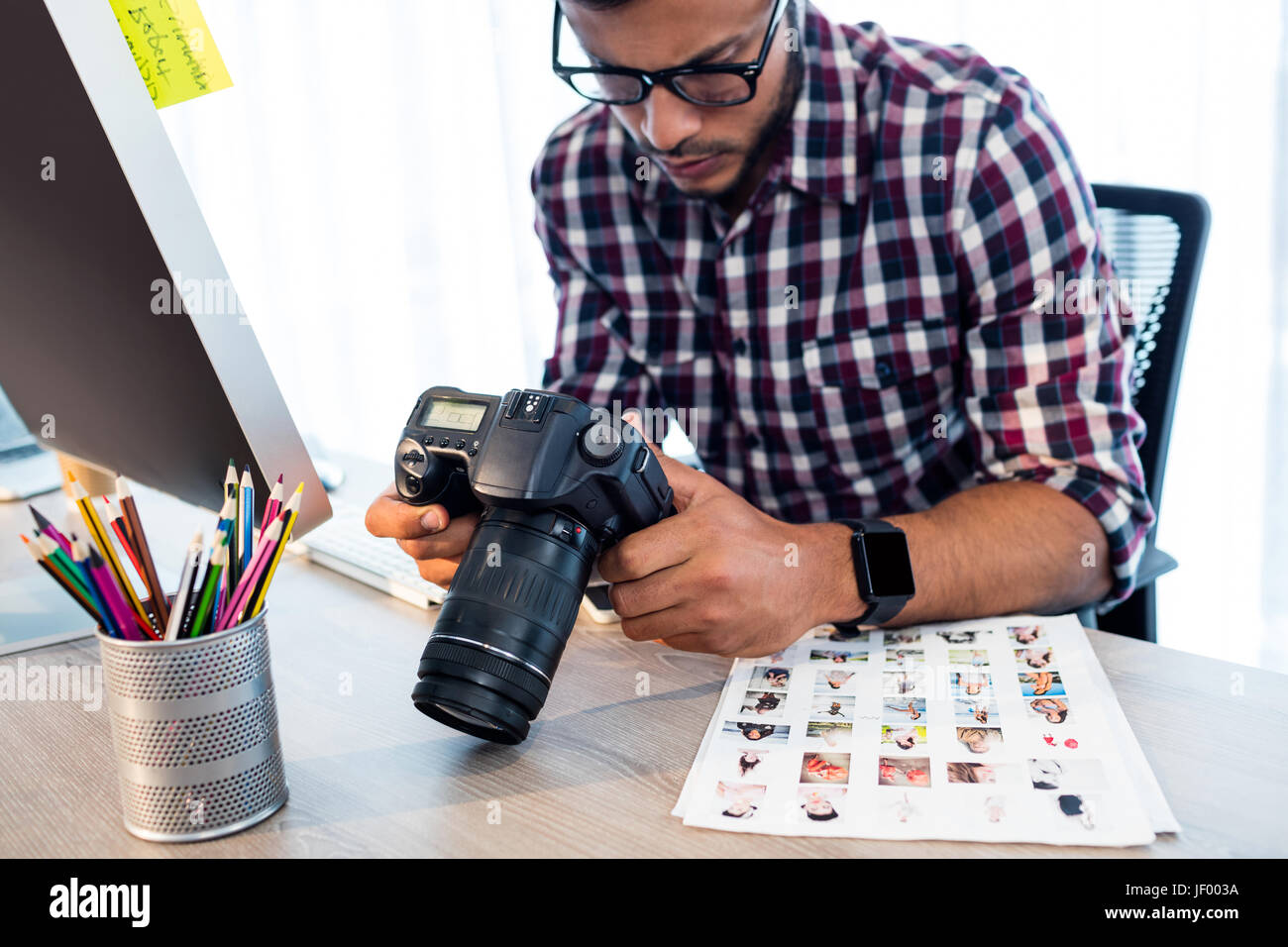 Side view of photographer working at desk Stock Photo - Alamy
