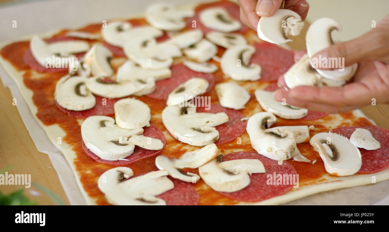 Woman making a delicious pepperoni pizza Stock Photo - Alamy