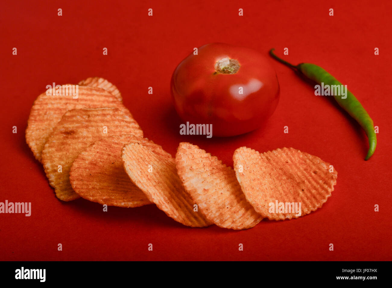 spicy Potato chips arranged with tomato and green chili Stock Photo - Alamy