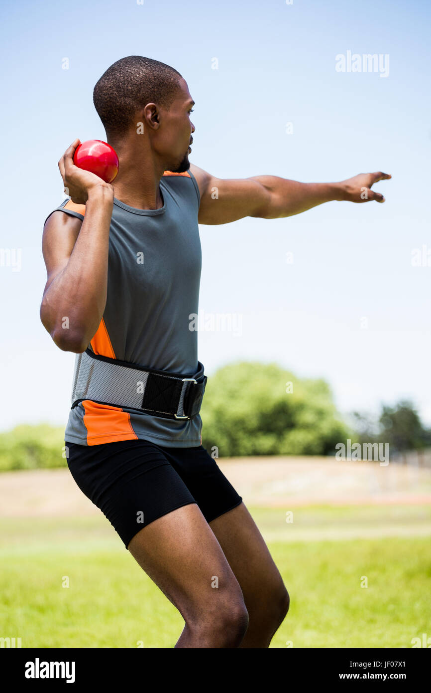 Male athlete about to throw shot put ball Stock Photo - Alamy
