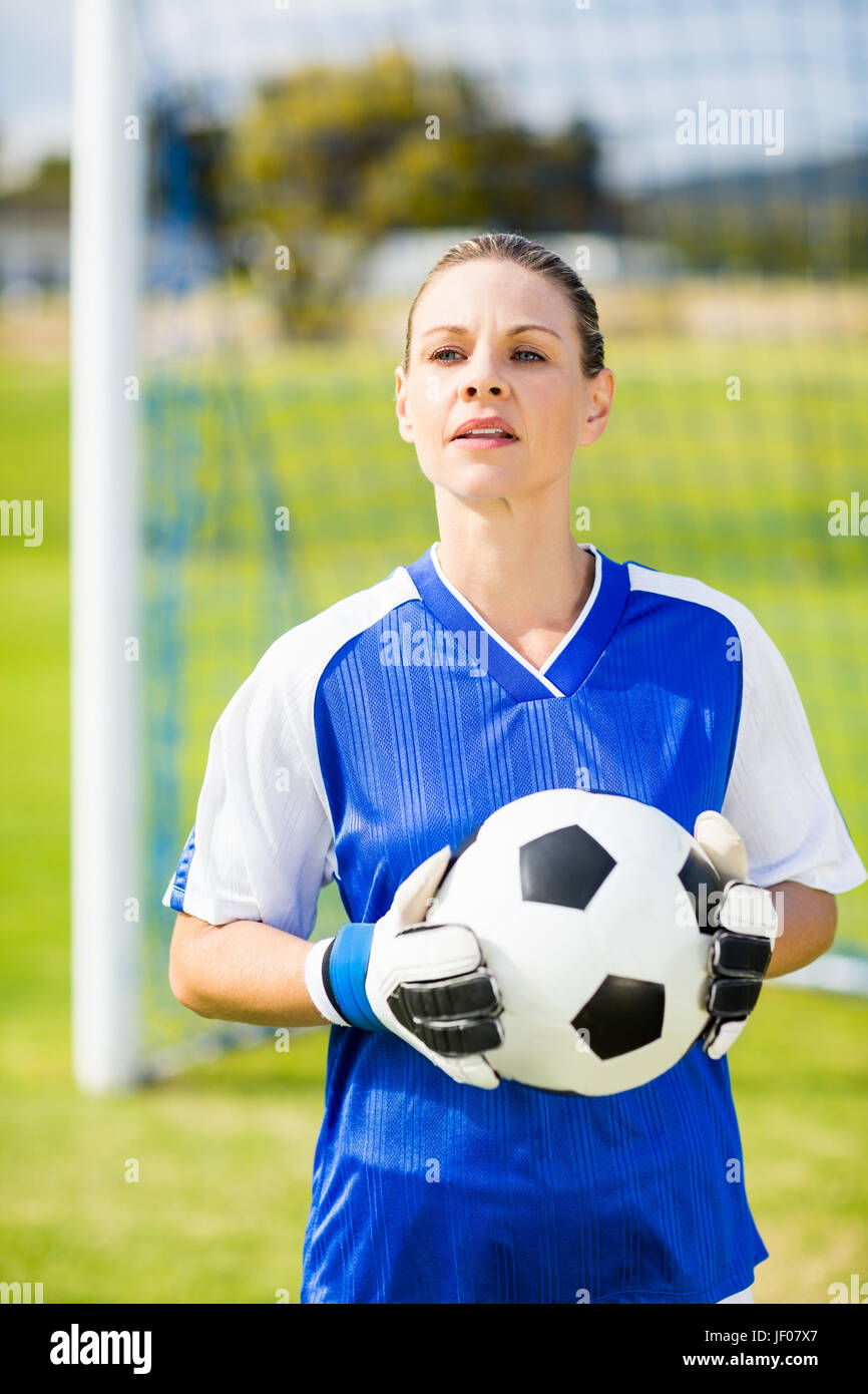 Female goalkeeper standing with ball Stock Photo - Alamy