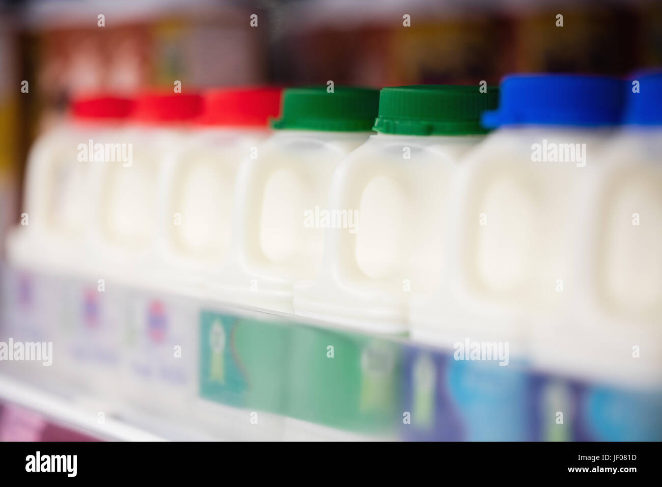 Milk bottles tidied in shelf Stock Photo - Alamy