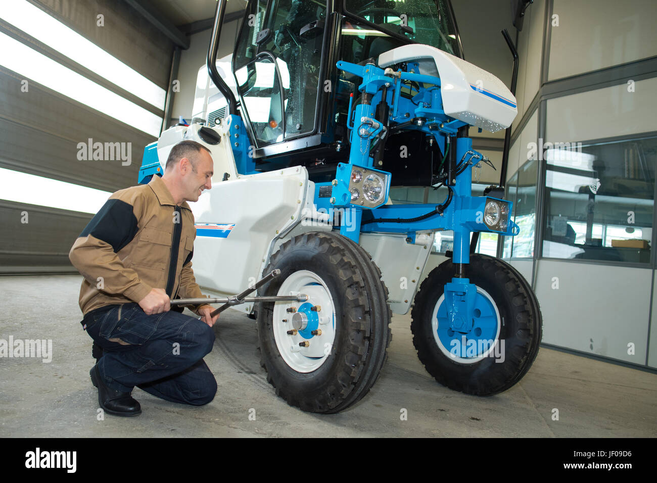 man fixing a tractor in an agro-industrial hardware Stock Photo - Alamy
