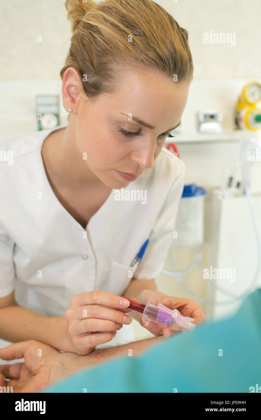 doctor sticking needle into male arm for blood sampling Stock Photo - Alamy