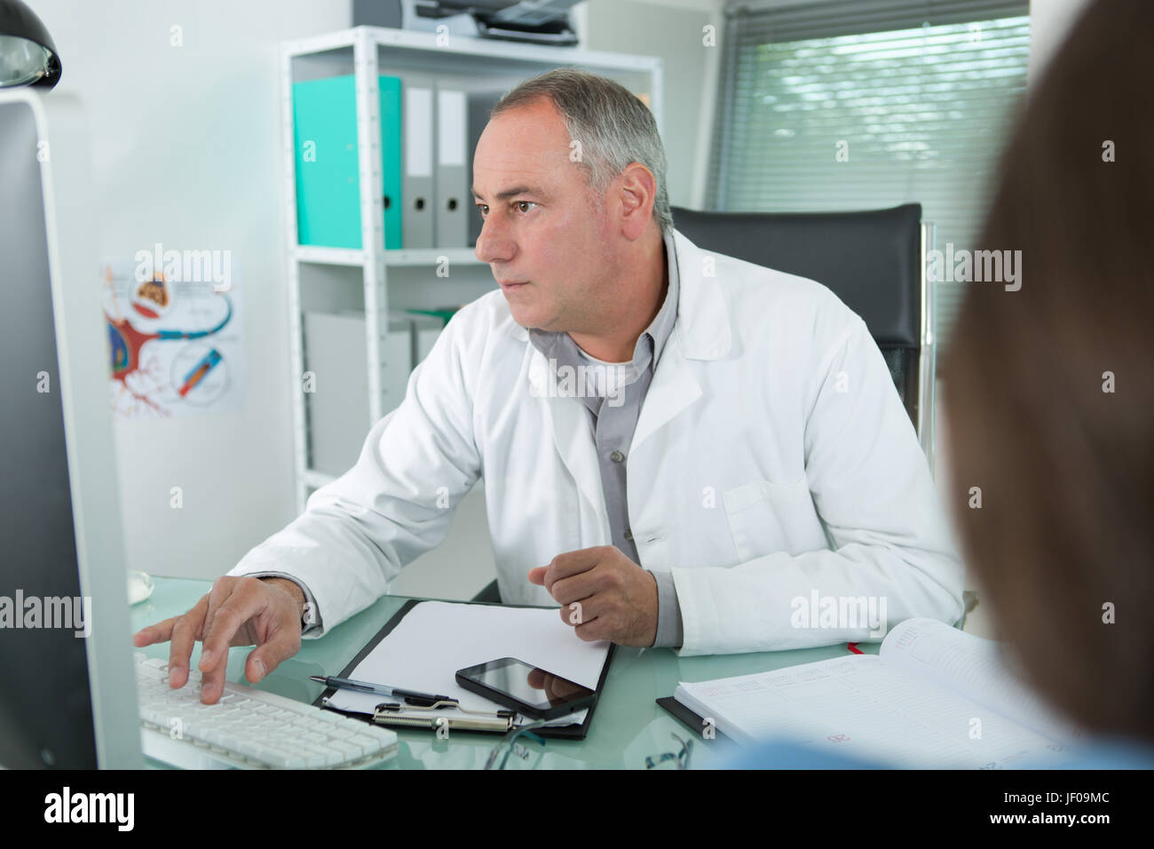 Medical worker using computer during consultation Stock Photo - Alamy