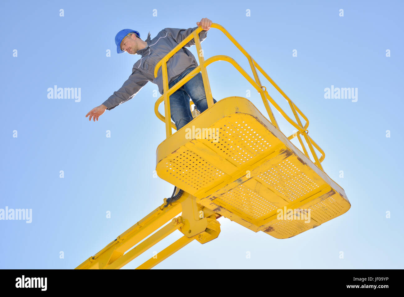 Man in cherry picker bucket pointing into distance Stock Photo - Alamy
