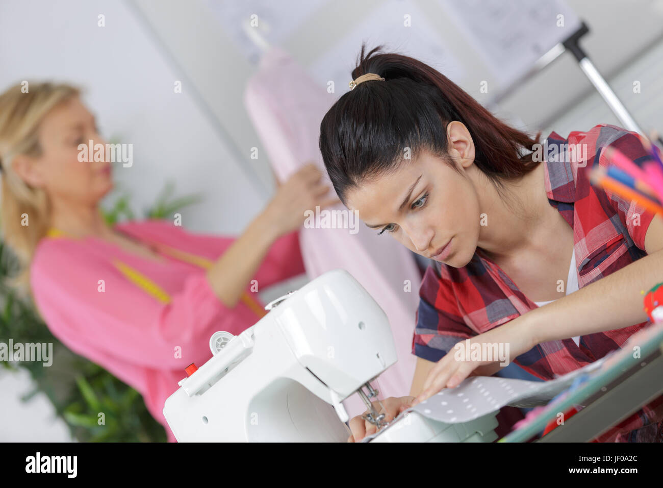 Young lady using sewing machine Stock Photo - Alamy