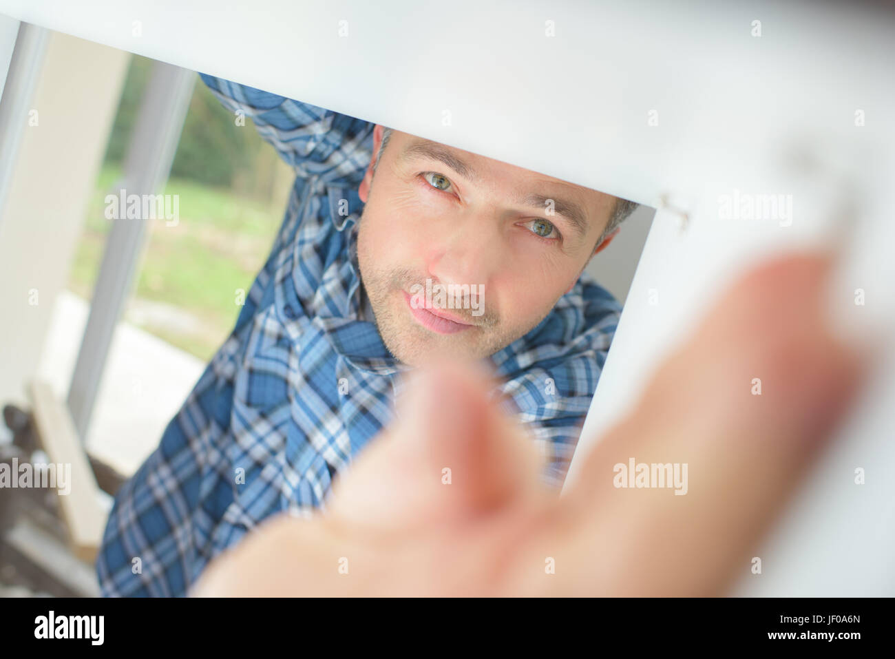 View of man mounting mirror Stock Photo - Alamy