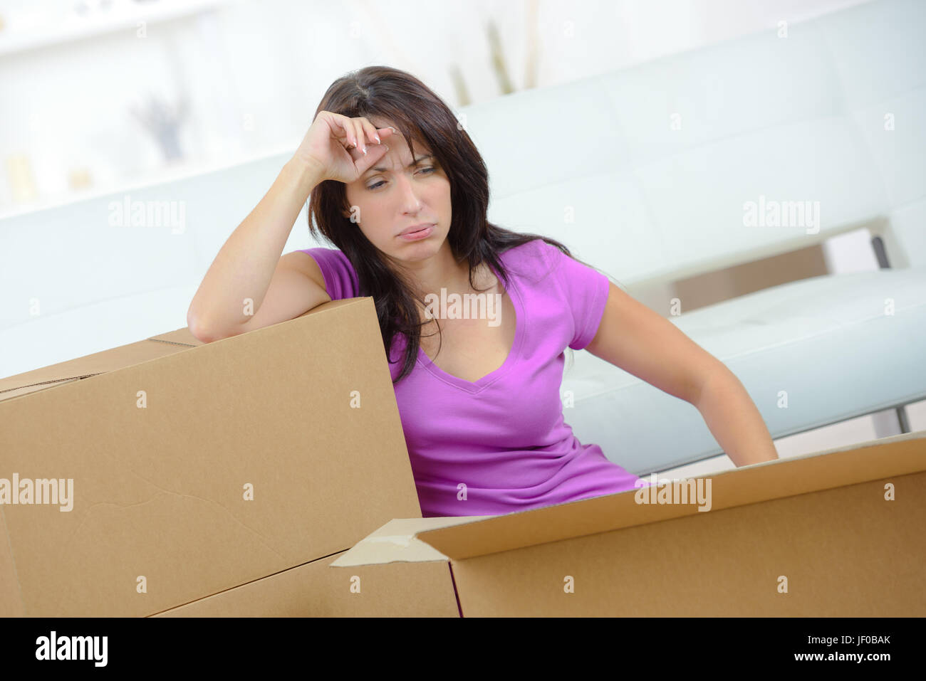 Sad woman packing boxes hi-res stock photography and images - Alamy