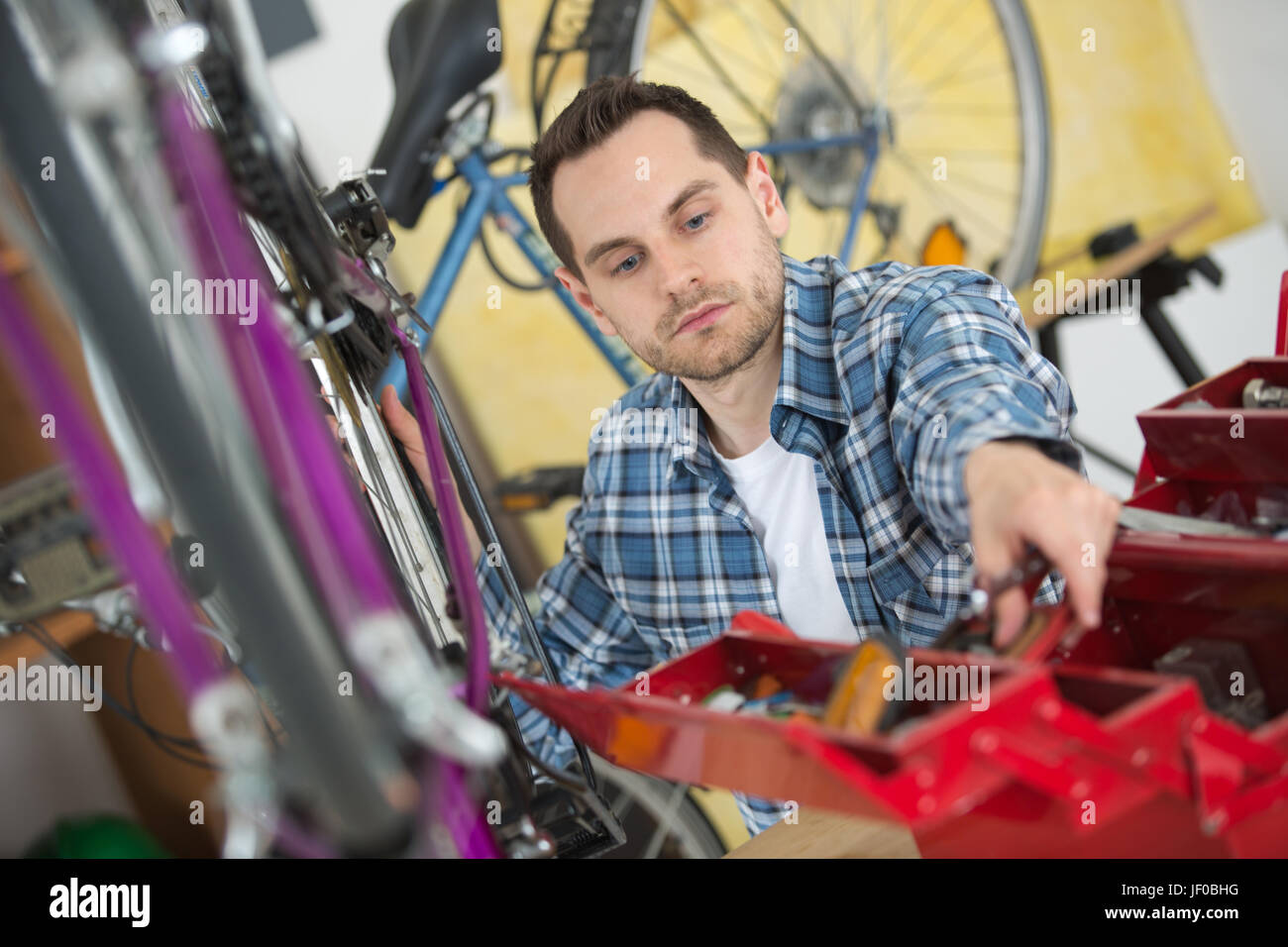 Mechanic reaching for tool to repair bicycle Stock Photo - Alamy