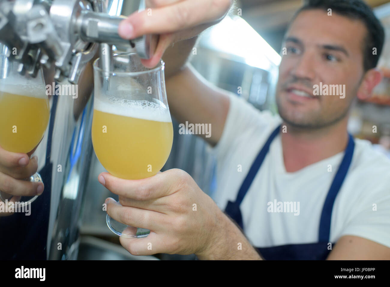 Man pouring glass of lager from barrel Stock Photo - Alamy