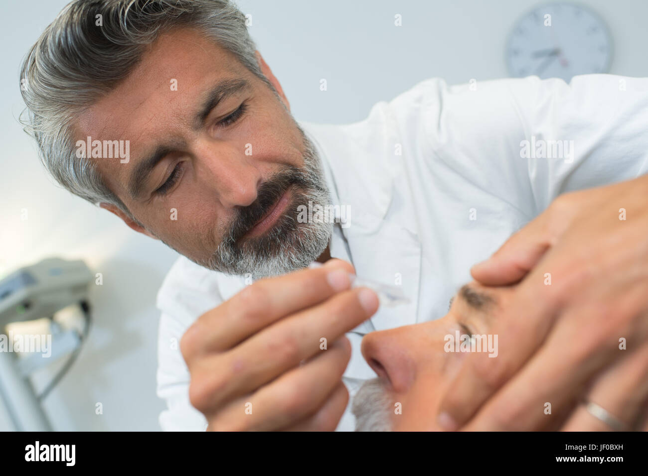 Doctor putting drops into patient's eye Stock Photo - Alamy