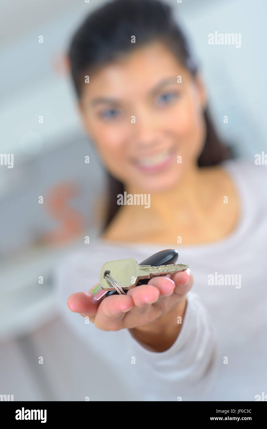 Lady holding keys in outstretched hand Stock Photo - Alamy