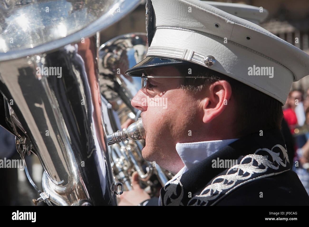 Musician blowing a wind instrument or tuba in a procession of holy week ...
