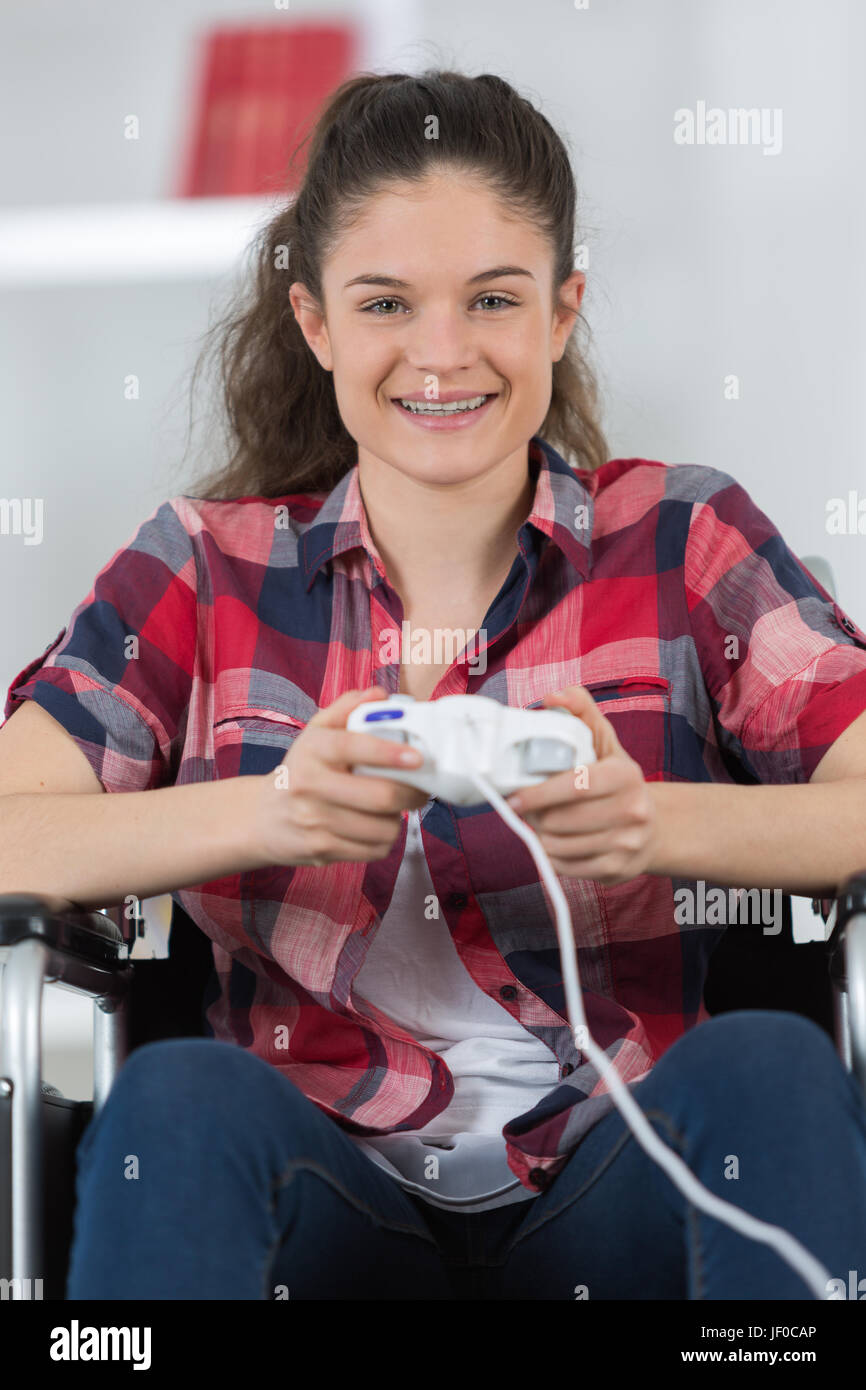 Portrait of teenager in wheelchair playing computer game Stock Photo ...
