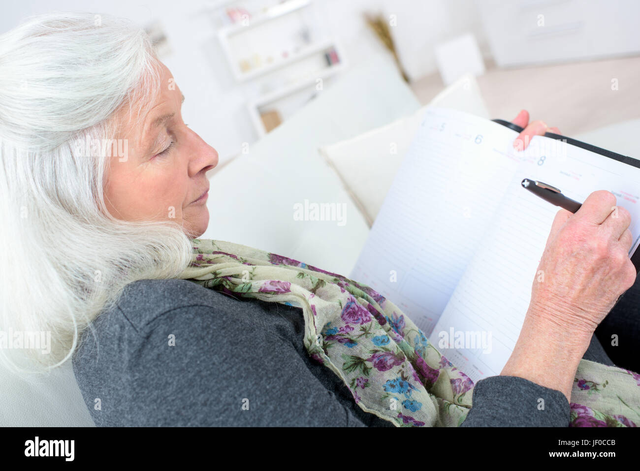 Elderly lady writing in notebook Stock Photo - Alamy