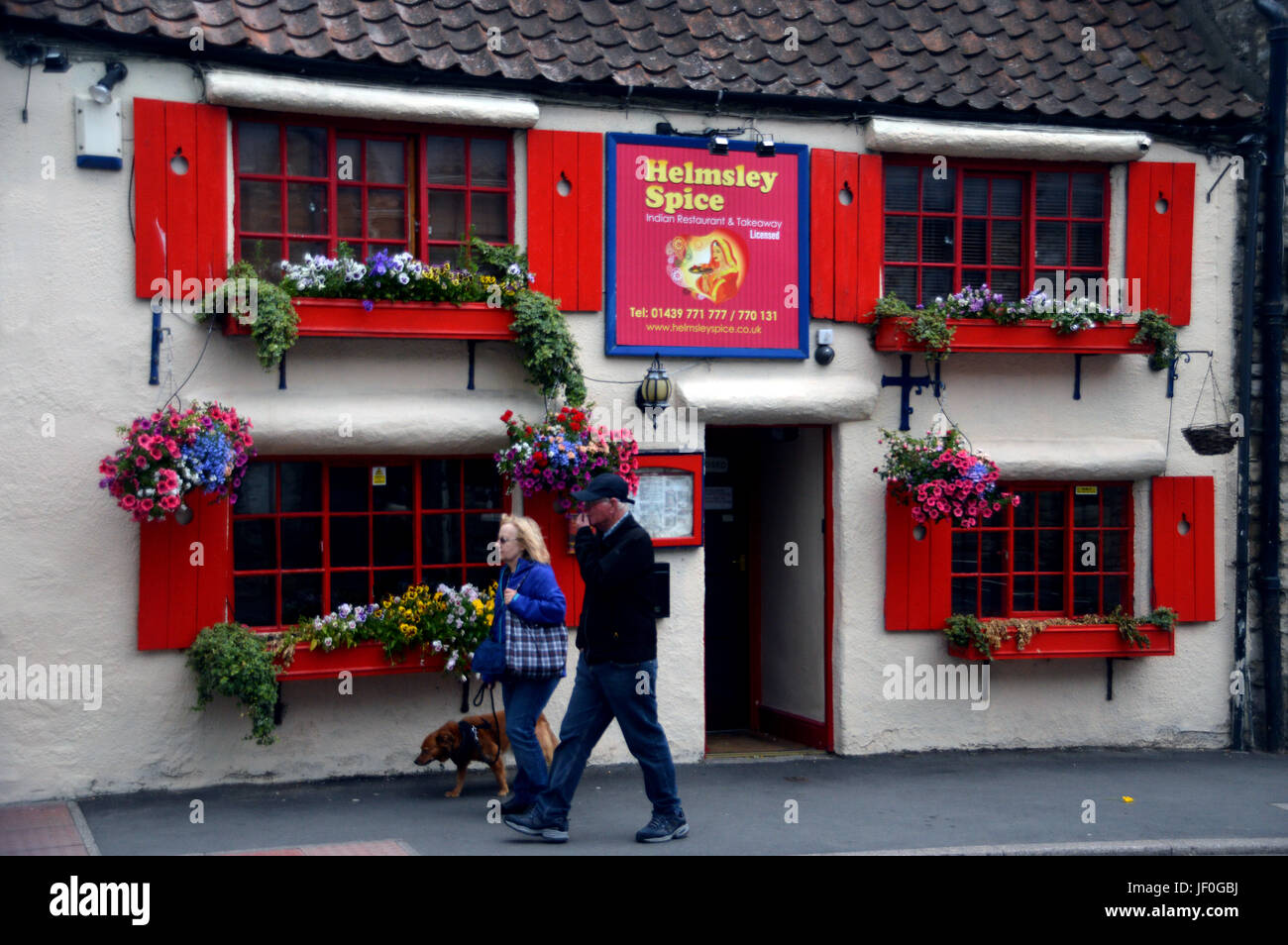 A Couple Walking There Dog Passed Helmsley Spice, Indian Restaurant in ...