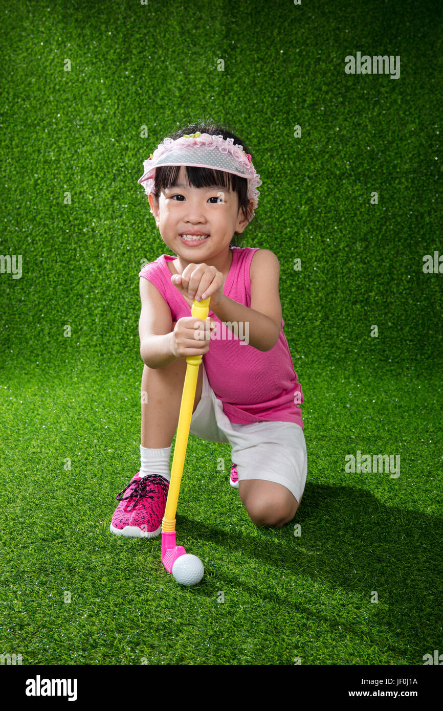 Asian Chinese little girl playing golf on green grass Stock Photo - Alamy