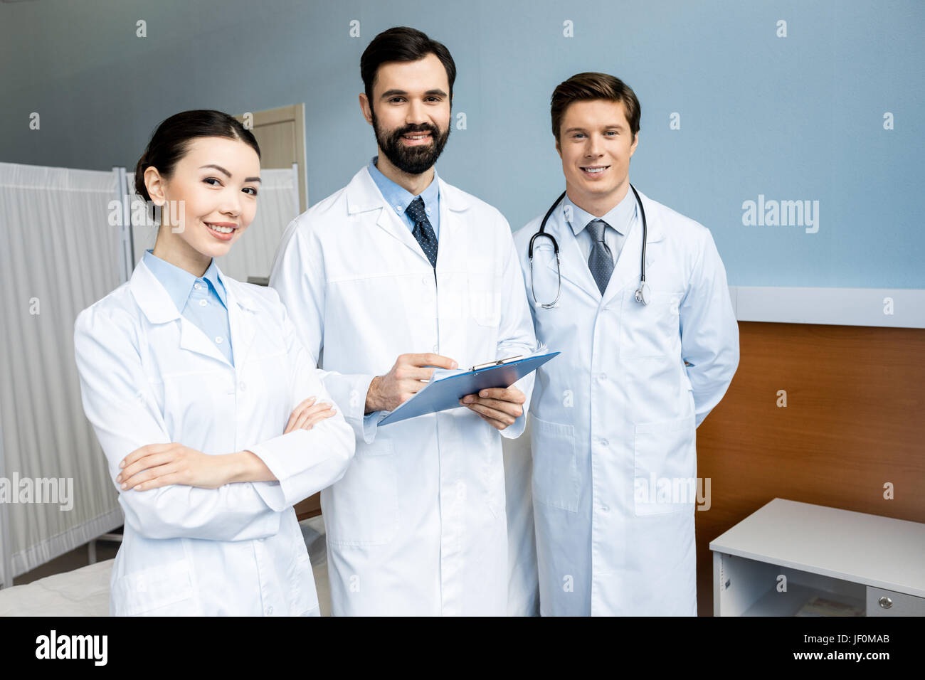 three doctors holding diagnosis and posing in hospital chamber Stock ...