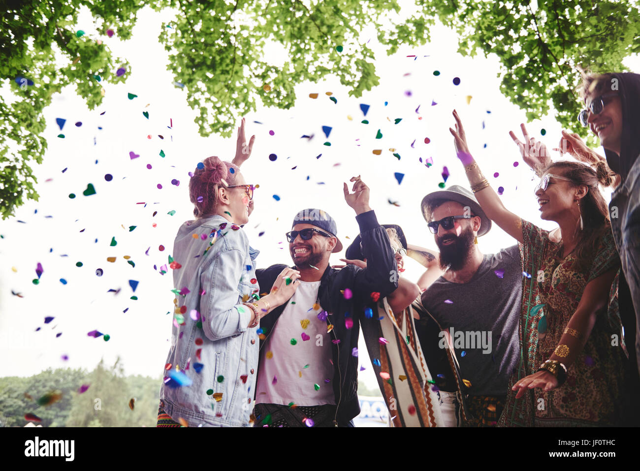 Group of friends dancing in confetti Stock Photo - Alamy