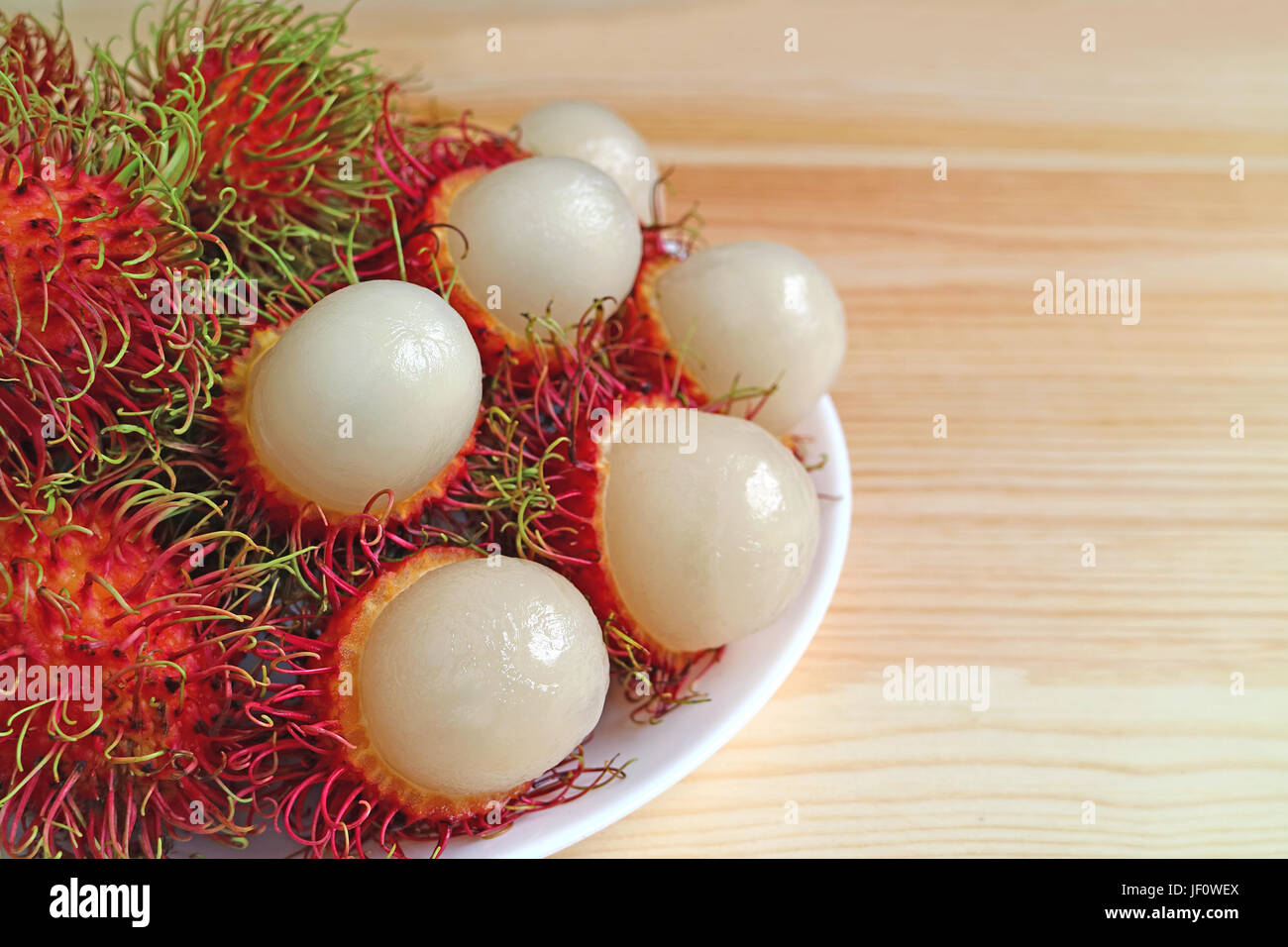 Plate of Ripe Rambutan Whole Fruits and Opened to Show Juicy White Meat ...