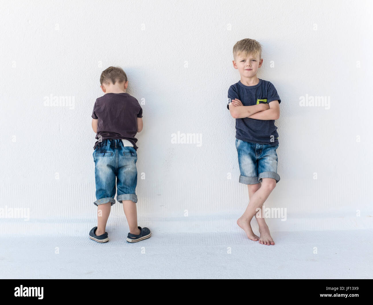Boys standing against wall Stock Photo - Alamy
