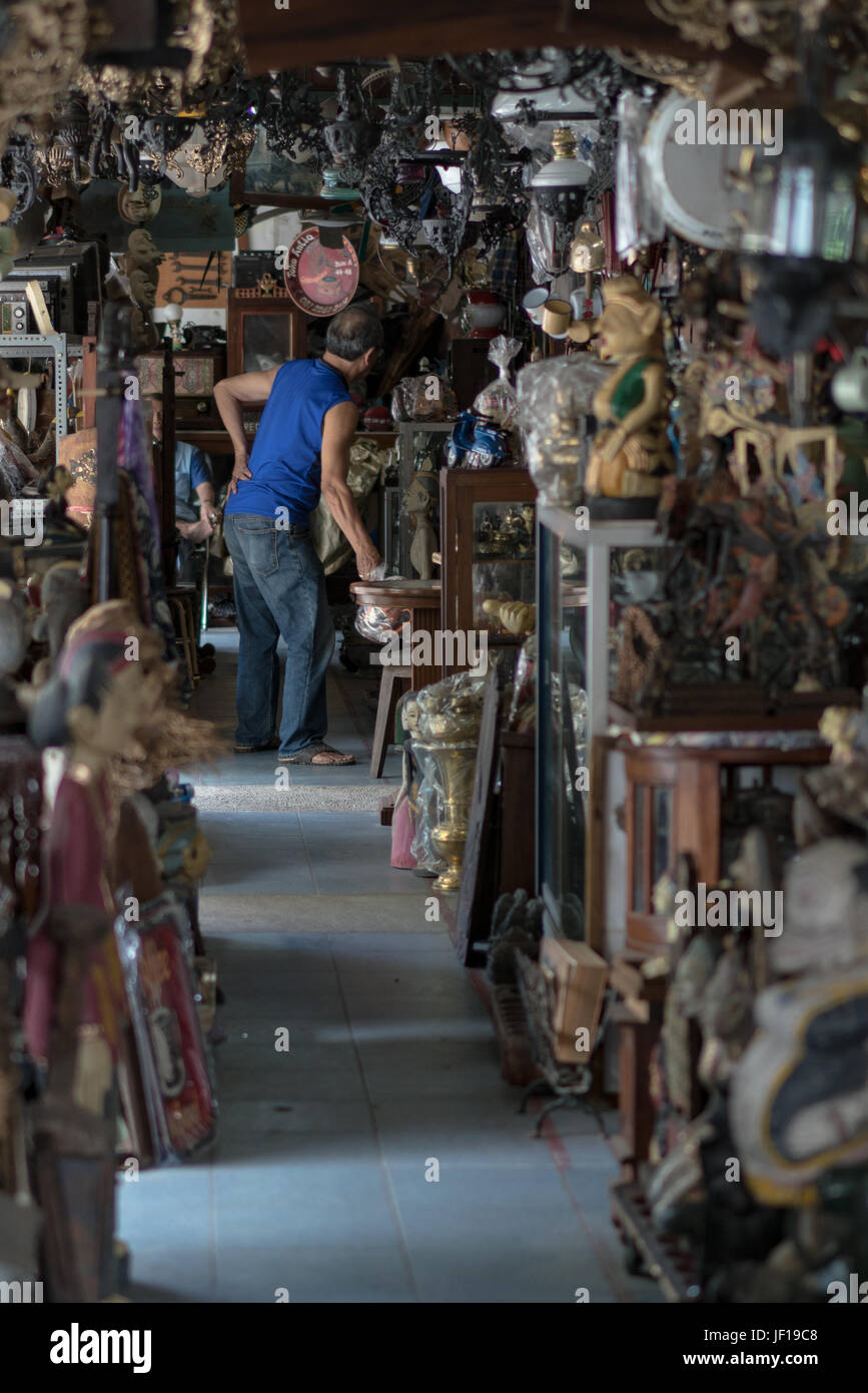 Antiques for sale at the Triwindu Market in Indonesia. Elderly man ...