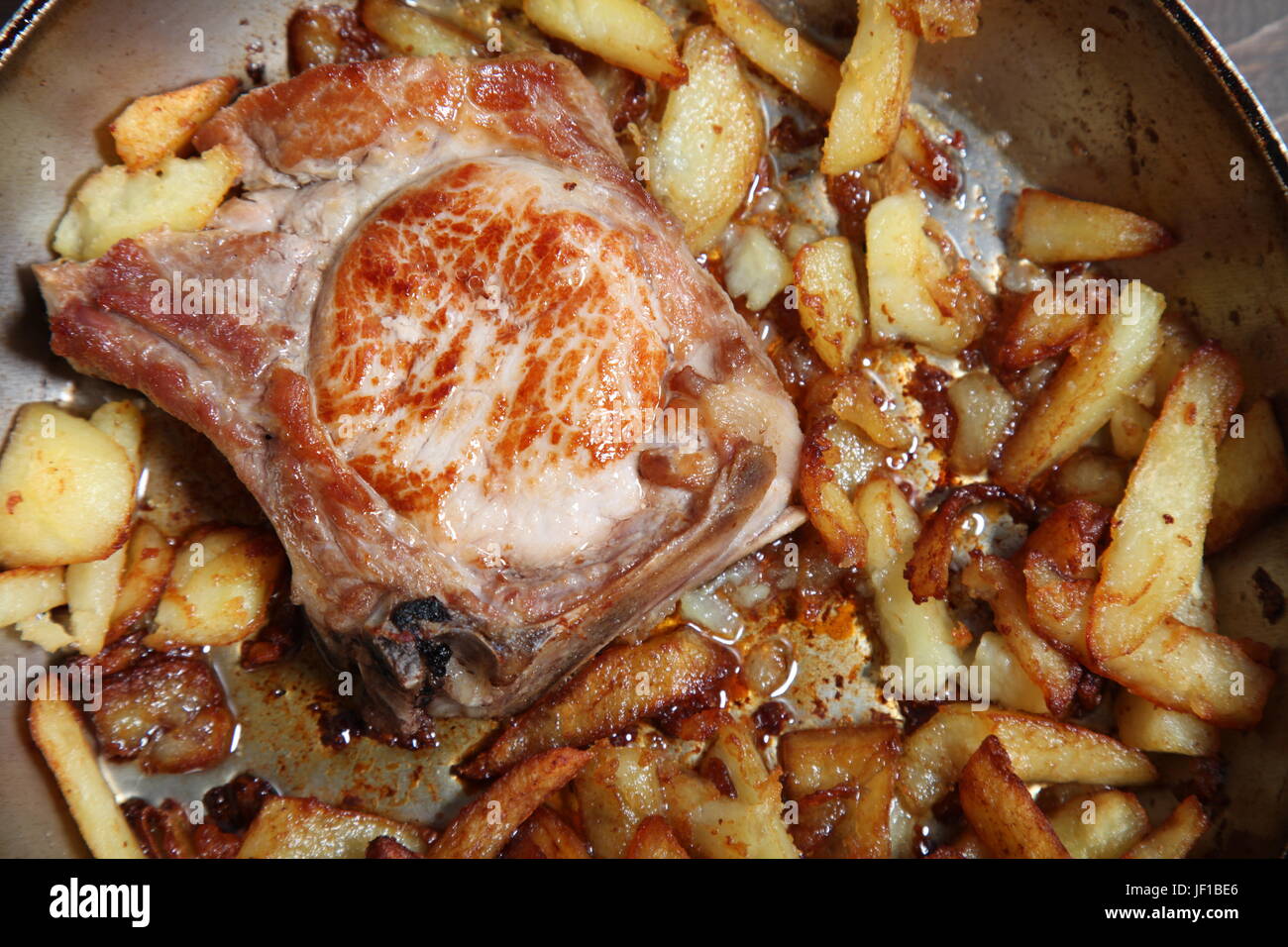 dinner with pan fried meat and potatoes on a table Stock Photo - Alamy