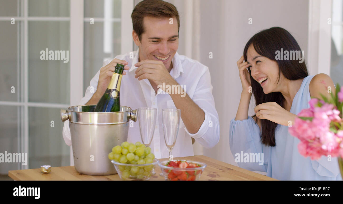 Shocked young couple during champagne opening Stock Photo - Alamy