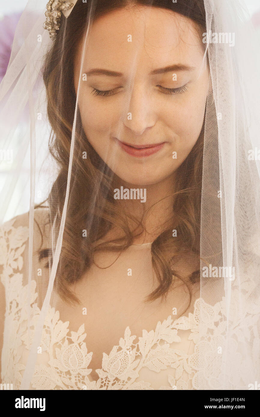 A young woman, a bride in a wedding dress with lace bodice, and a net ...