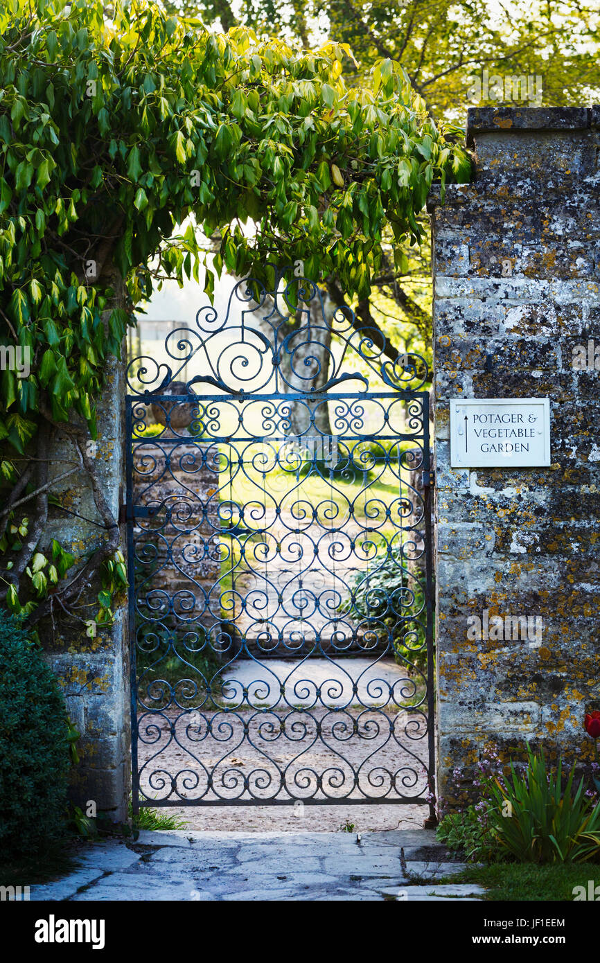 Branch of tree hanging over a wrough iron gate in a garden Stock Photo ...