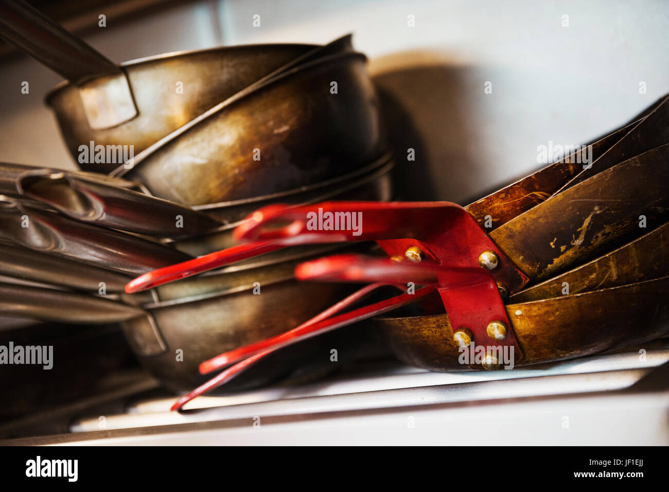 Close up of stacks of pots and pans on a shelf in a restaurant kitchen Stock Photo - Alamy