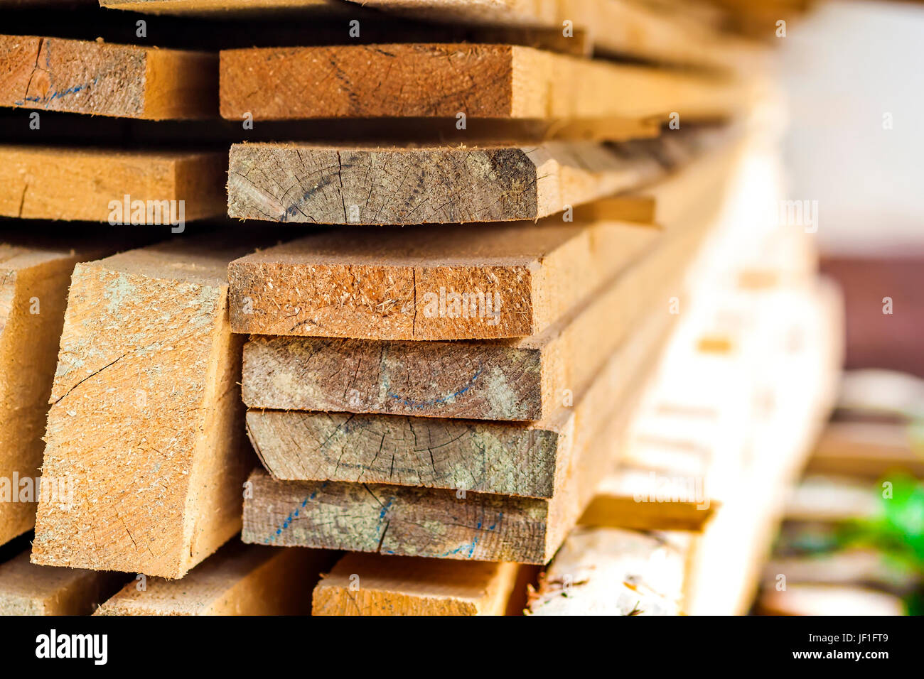 Stack of building lumber at construction site with narrow depth of ...
