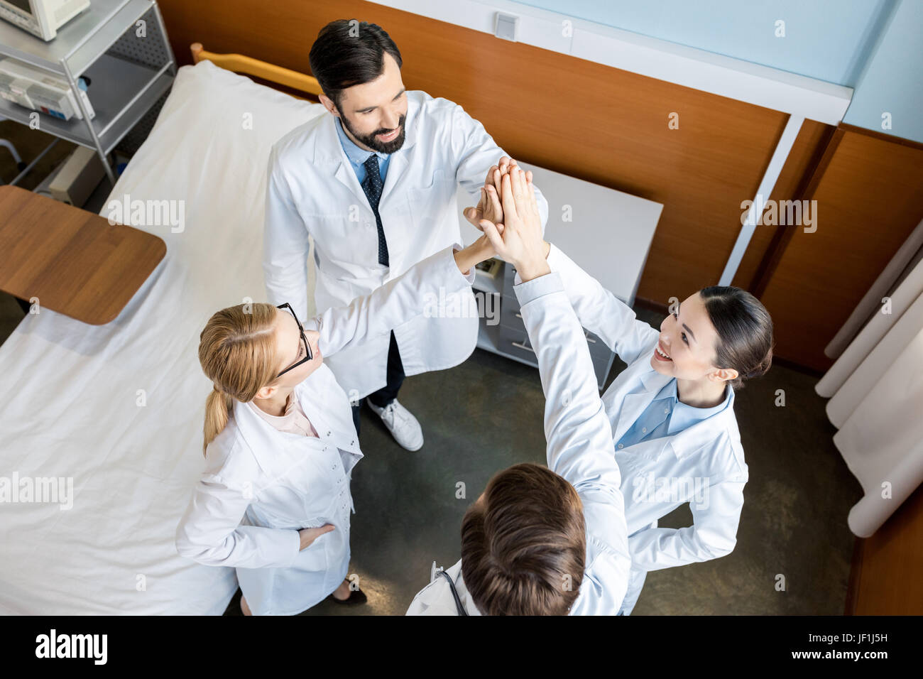 Group of professional young doctors holding hands together in hospital ...
