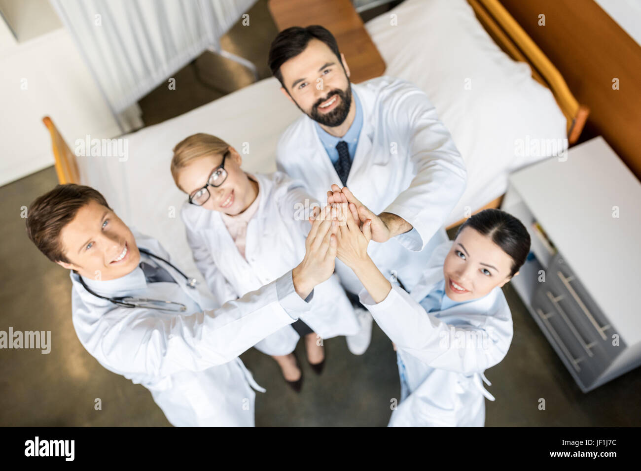 Group of professional young doctors holding hands together in hospital ...